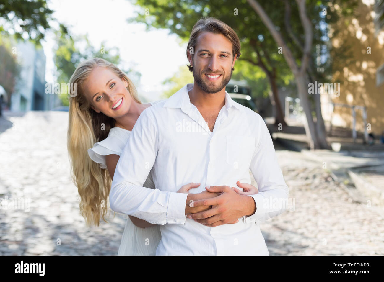 Attractive couple hugging each other and smiling at camera Stock Photo ...
