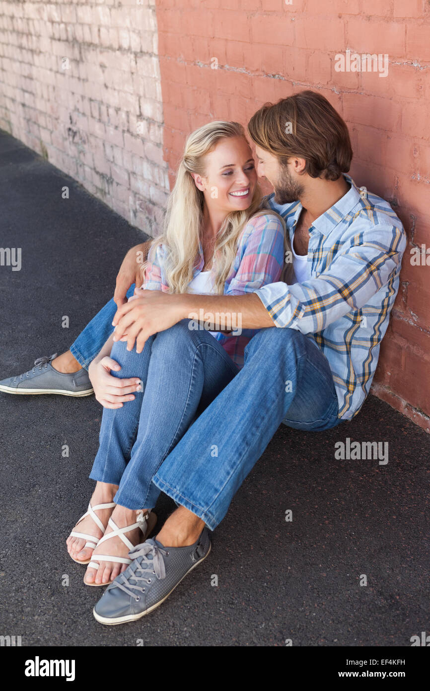 Cute couple sitting on ground Stock Photo - Alamy