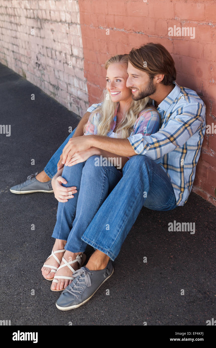 Cute couple sitting on ground Stock Photo - Alamy