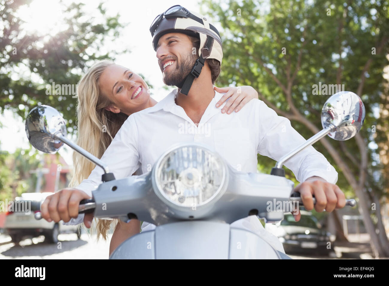 Cute couple riding a scooter Stock Photo - Alamy