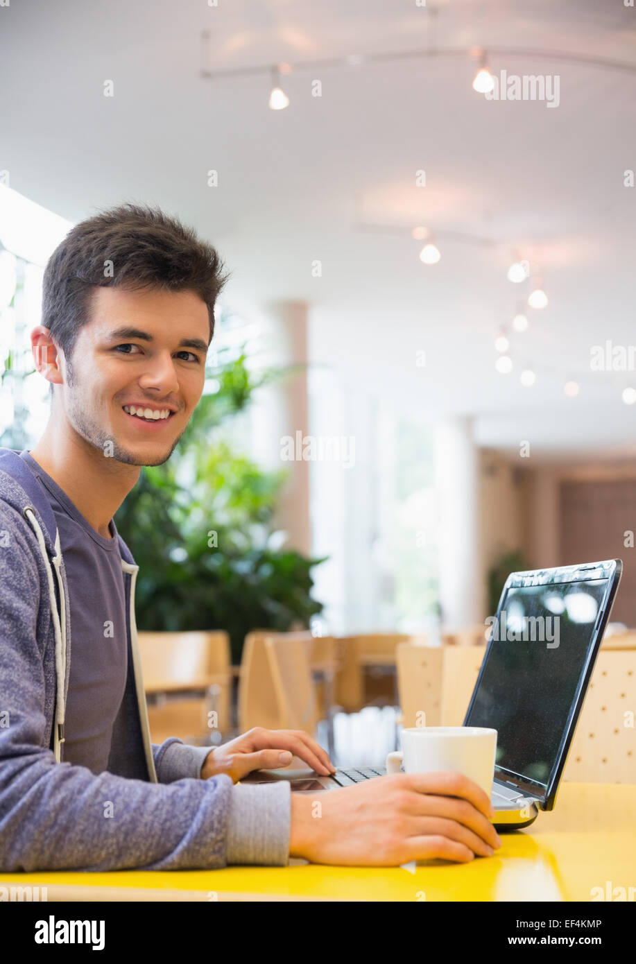 Young student using his laptop in cafe Stock Photo - Alamy