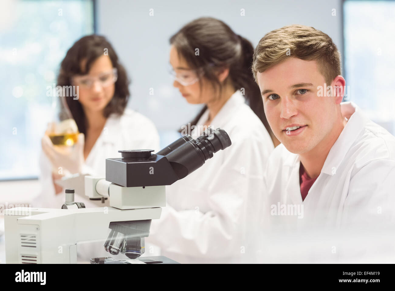 Science student looking through microscope in the lab Stock Photo - Alamy