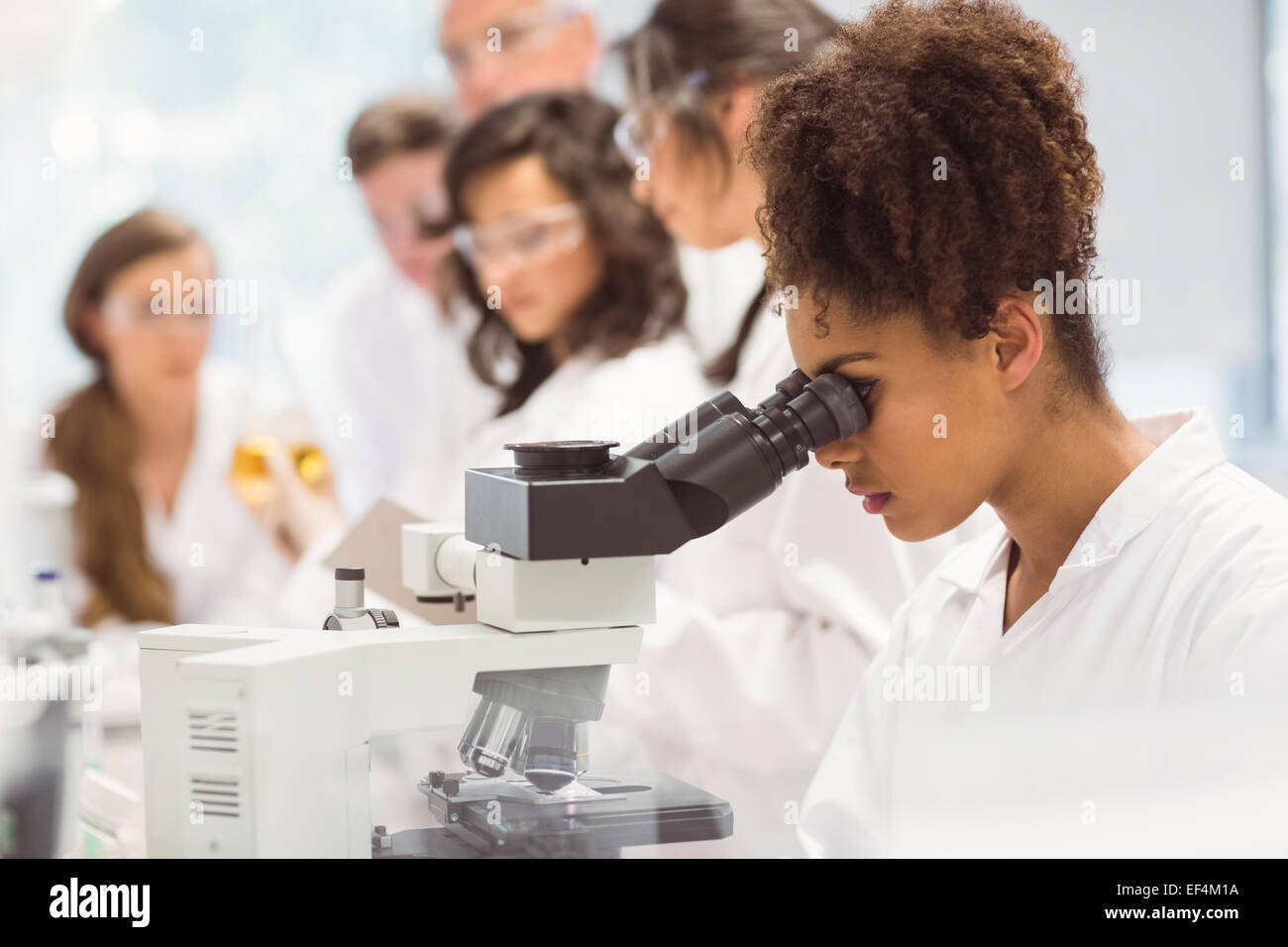 Science student looking through microscope in the lab Stock Photo - Alamy