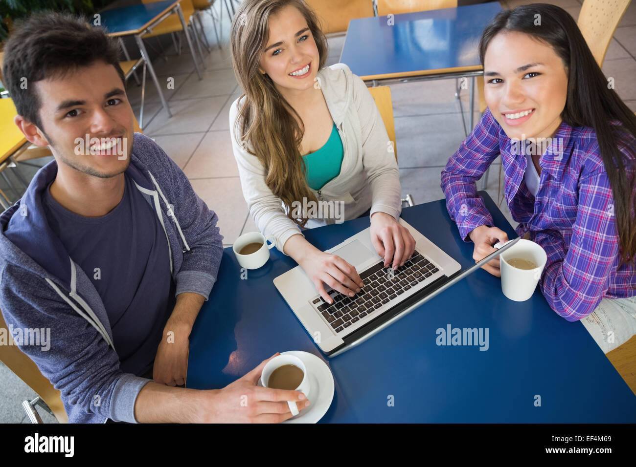 Young students doing assignment on laptop together Stock Photo - Alamy