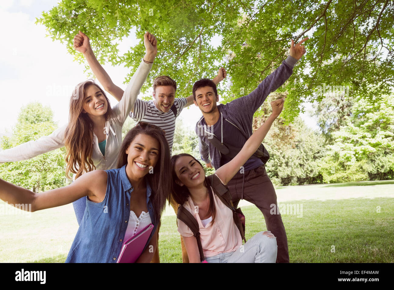 Happy students posing and smiling outside Stock Photo - Alamy