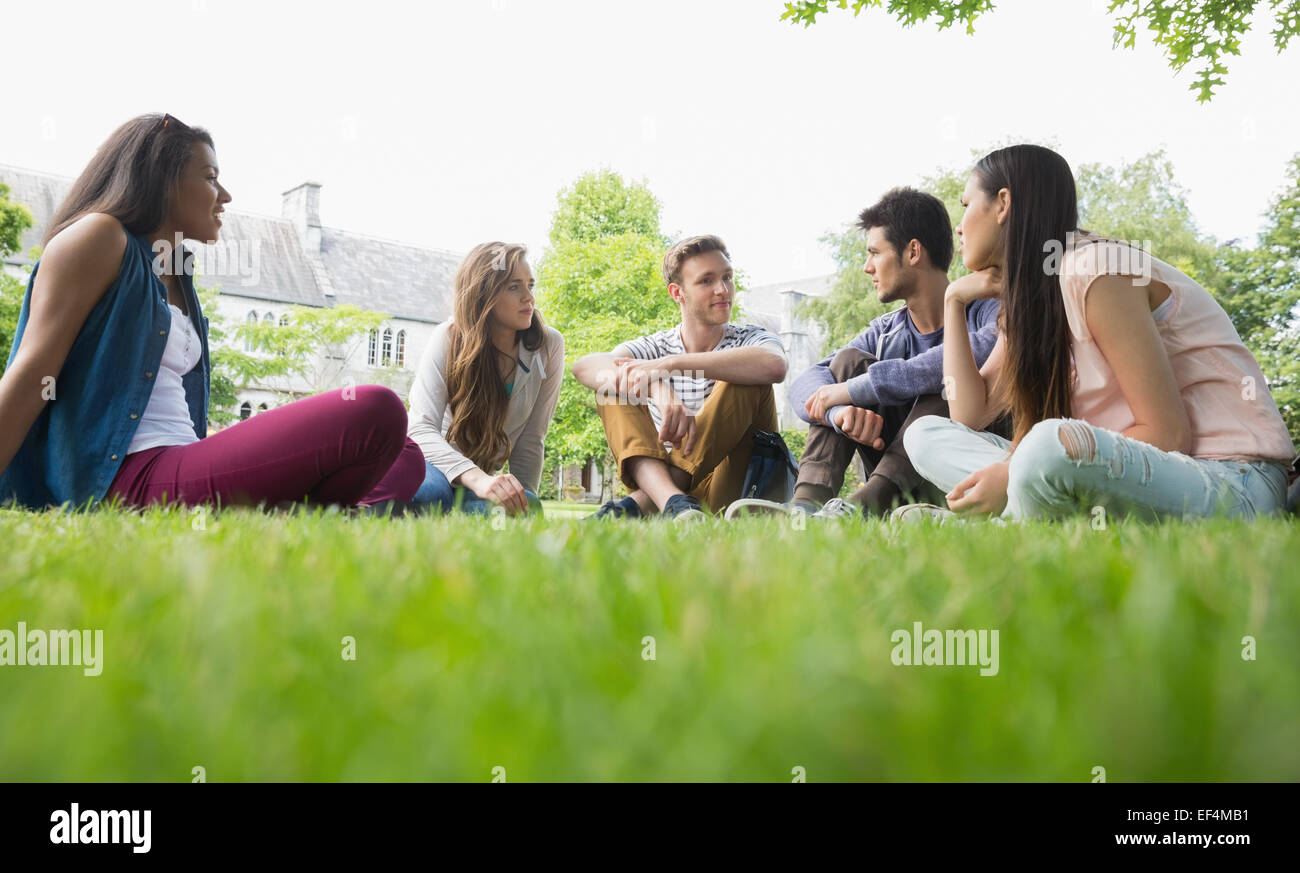 Happy students sitting outside on campus Stock Photo - Alamy