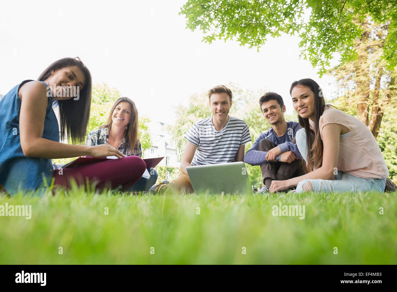 Happy students sitting outside on campus Stock Photo - Alamy