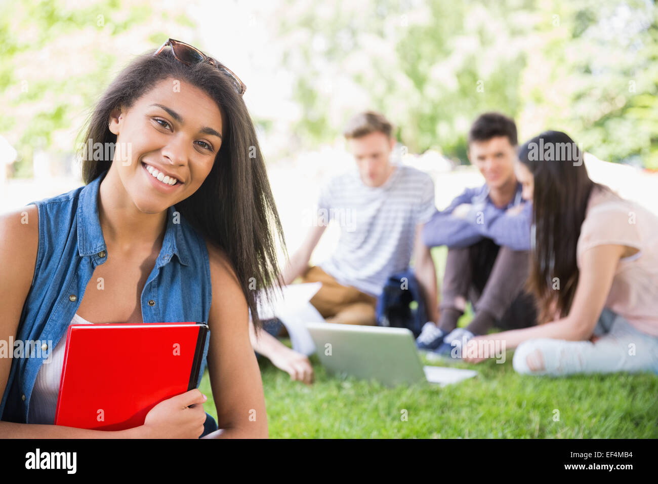 Happy students sitting outside on campus Stock Photo - Alamy