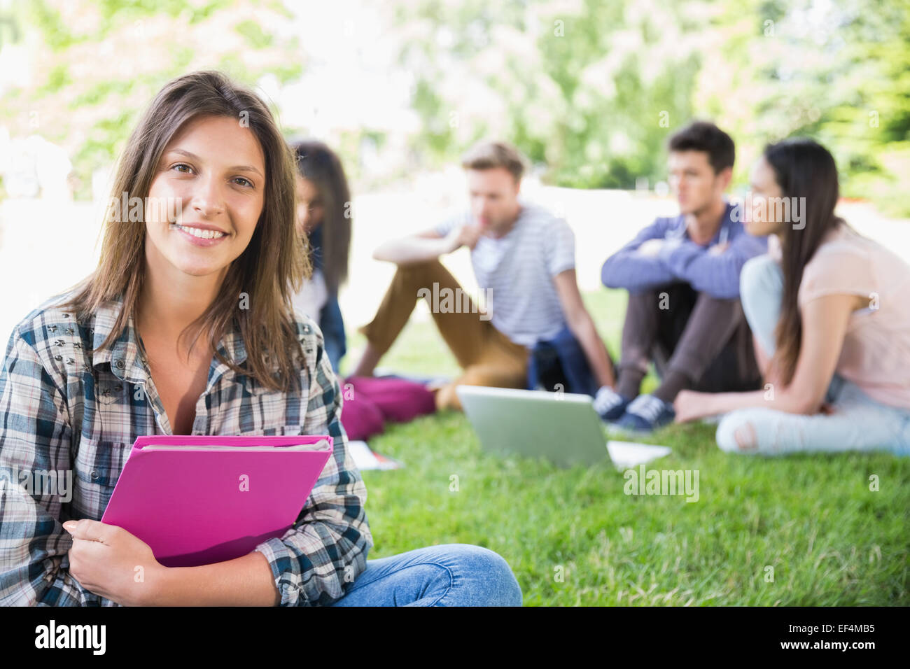 Happy students sitting outside on campus Stock Photo - Alamy