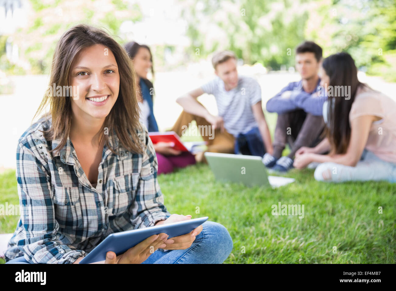 Happy students sitting outside on campus Stock Photo - Alamy