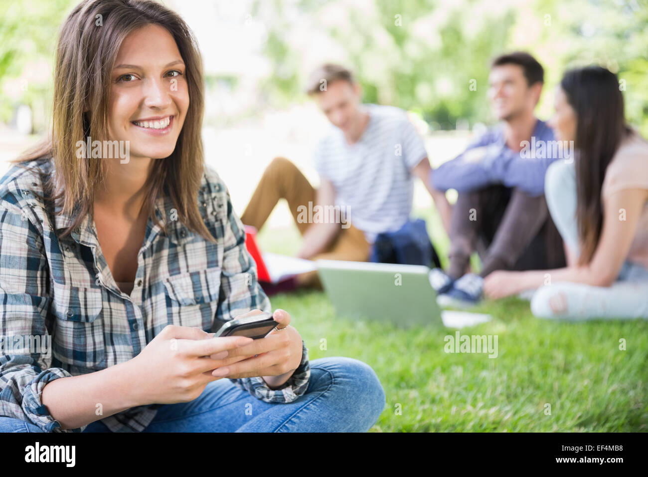 Happy students sitting outside on campus Stock Photo - Alamy