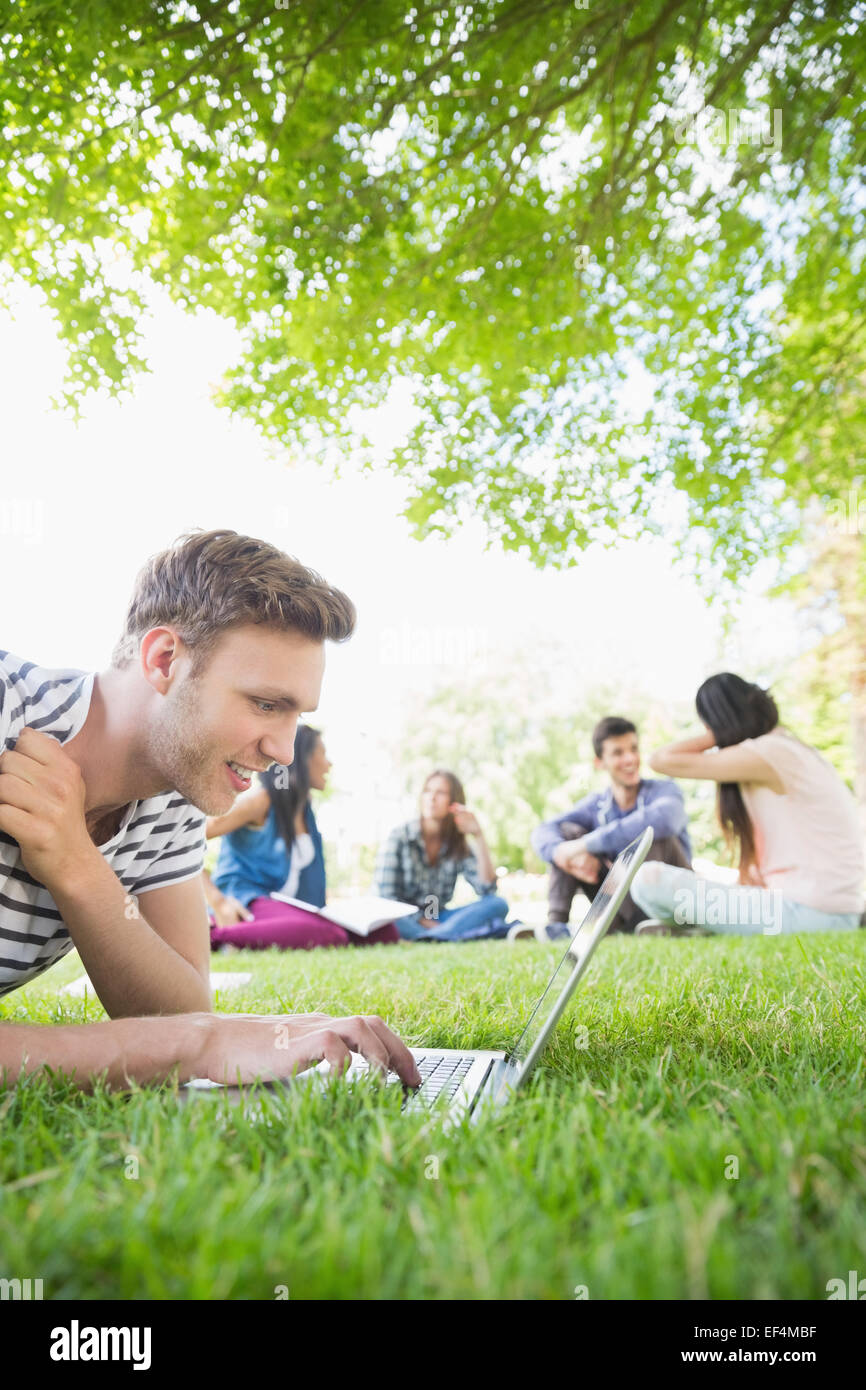 Happy student using his laptop outside Stock Photo - Alamy