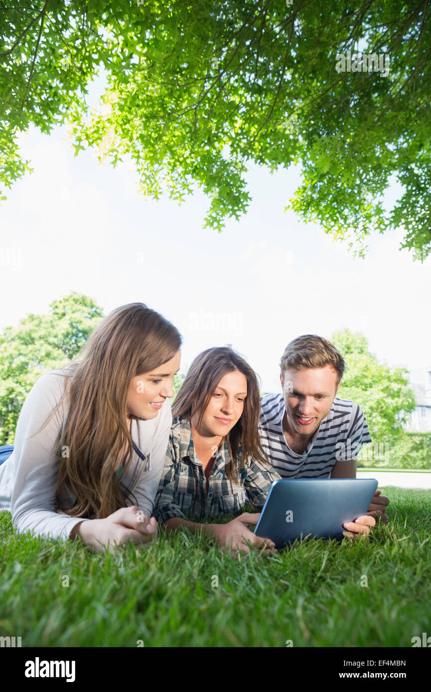 Happy students using tablet pc outside Stock Photo - Alamy