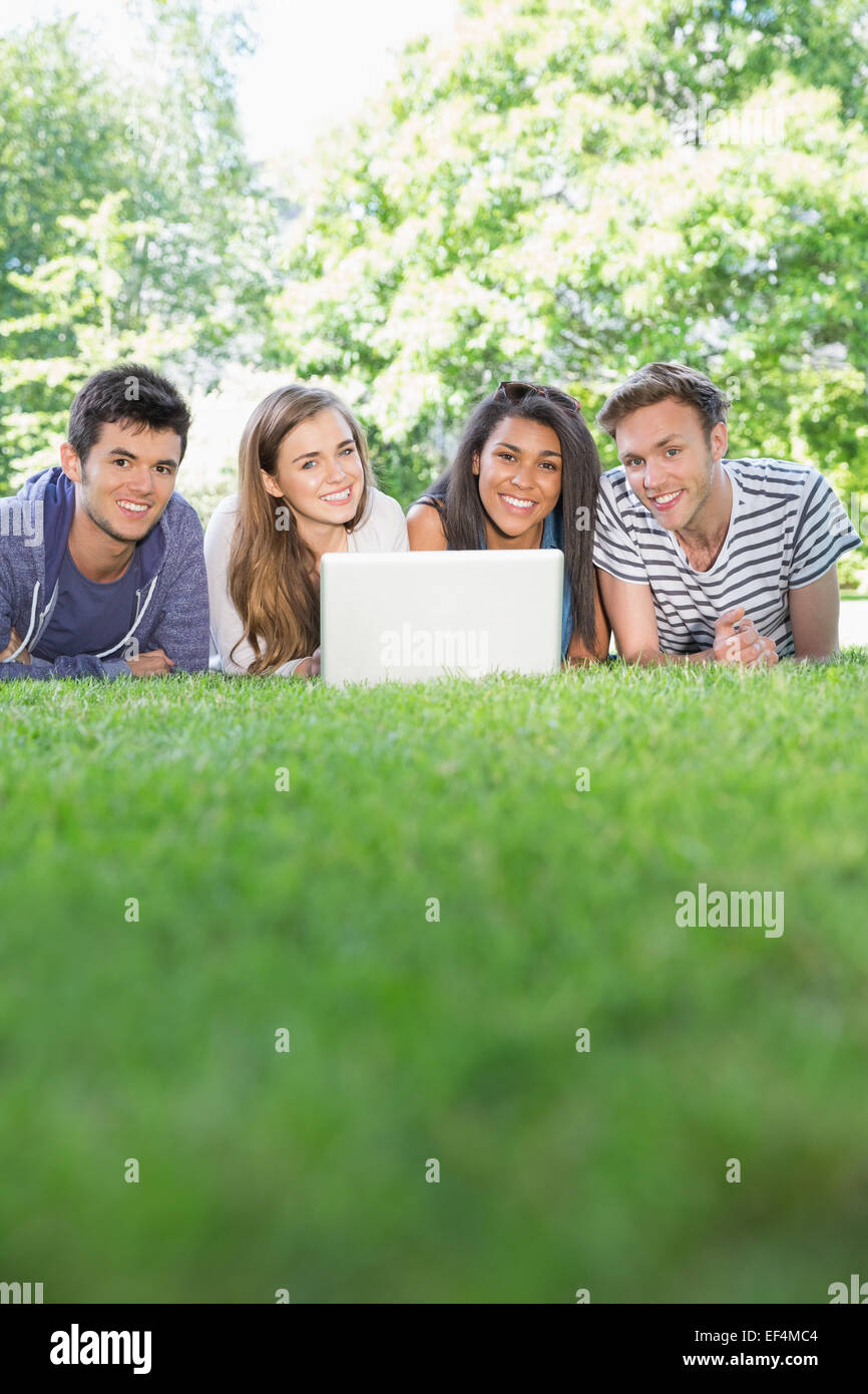 Happy students using laptop outside Stock Photo - Alamy