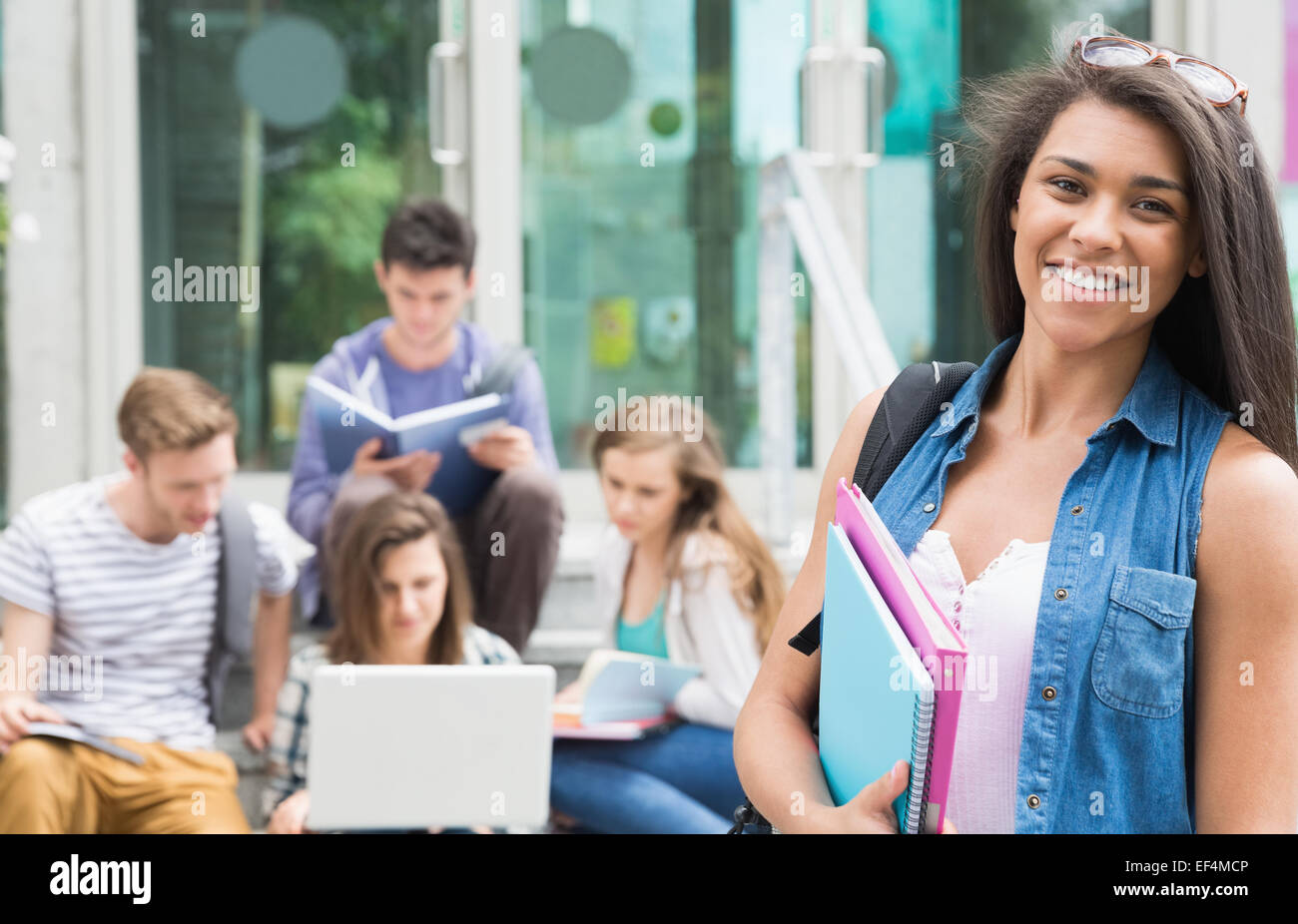 Pretty student smiling at camera outside Stock Photo - Alamy