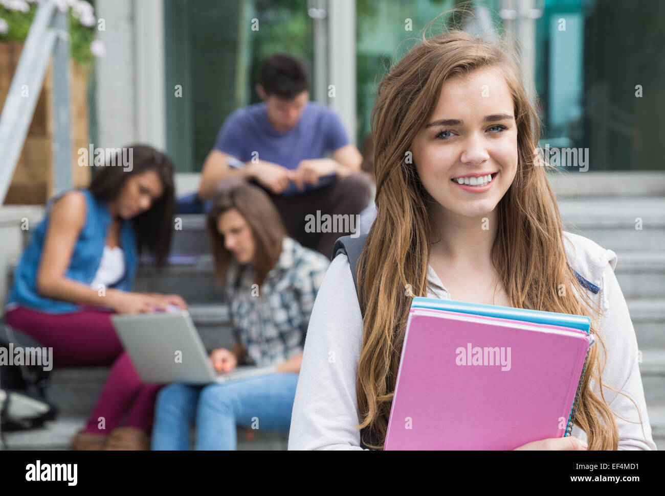 Pretty student smiling at camera outside Stock Photo - Alamy