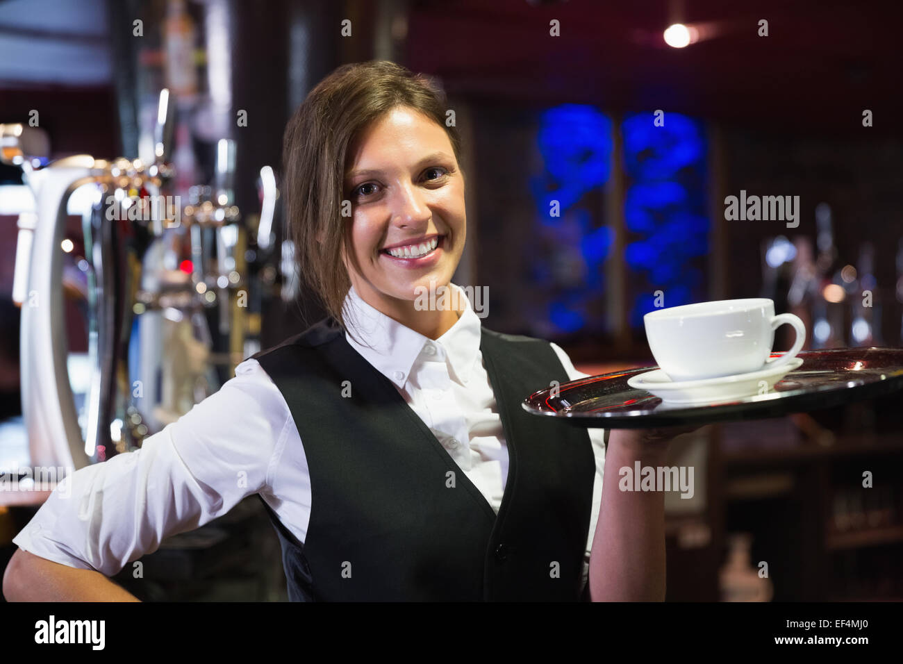 Happy barmaid holding tray with coffee Stock Photo - Alamy