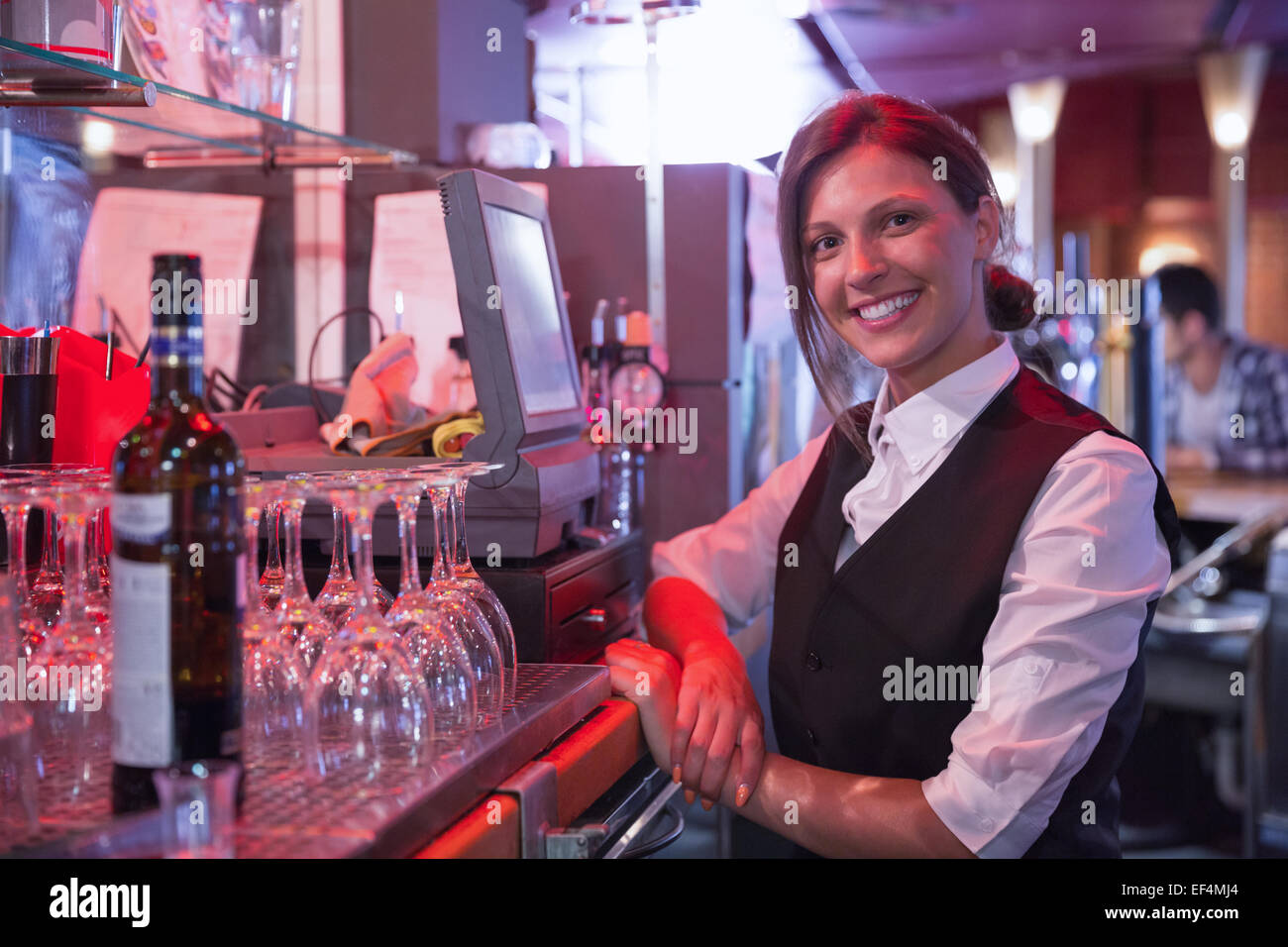Happy barmaid using touchscreen till Stock Photo - Alamy