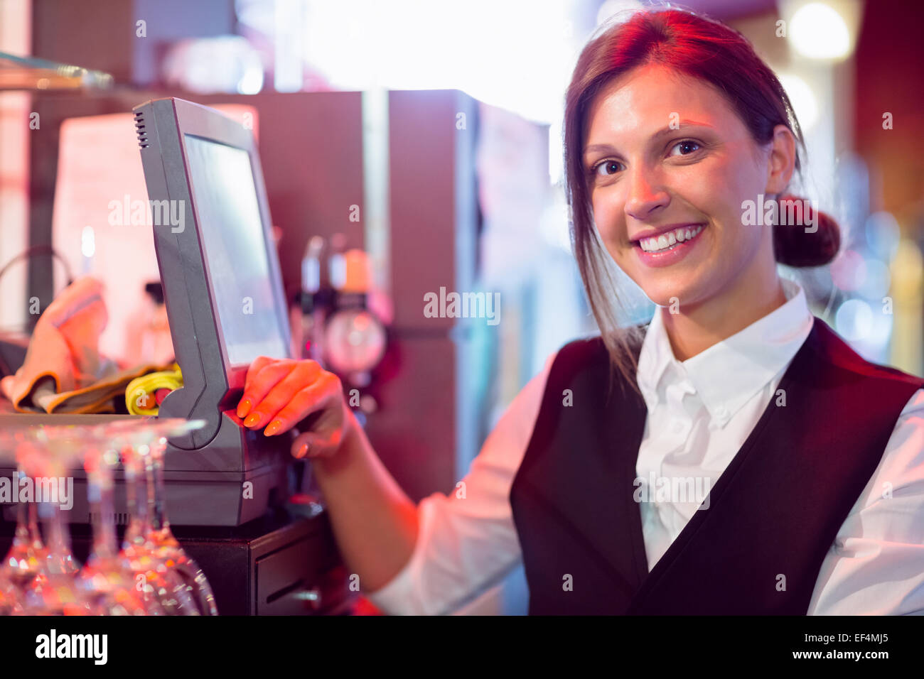 Happy barmaid using touchscreen till Stock Photo - Alamy