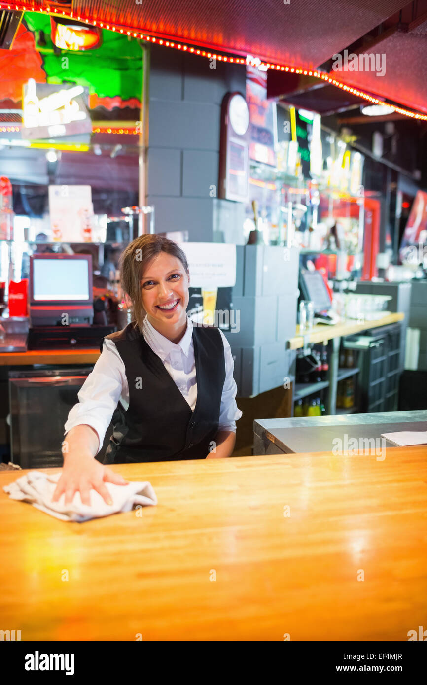 Pretty barmaid wiping down bar Stock Photo - Alamy