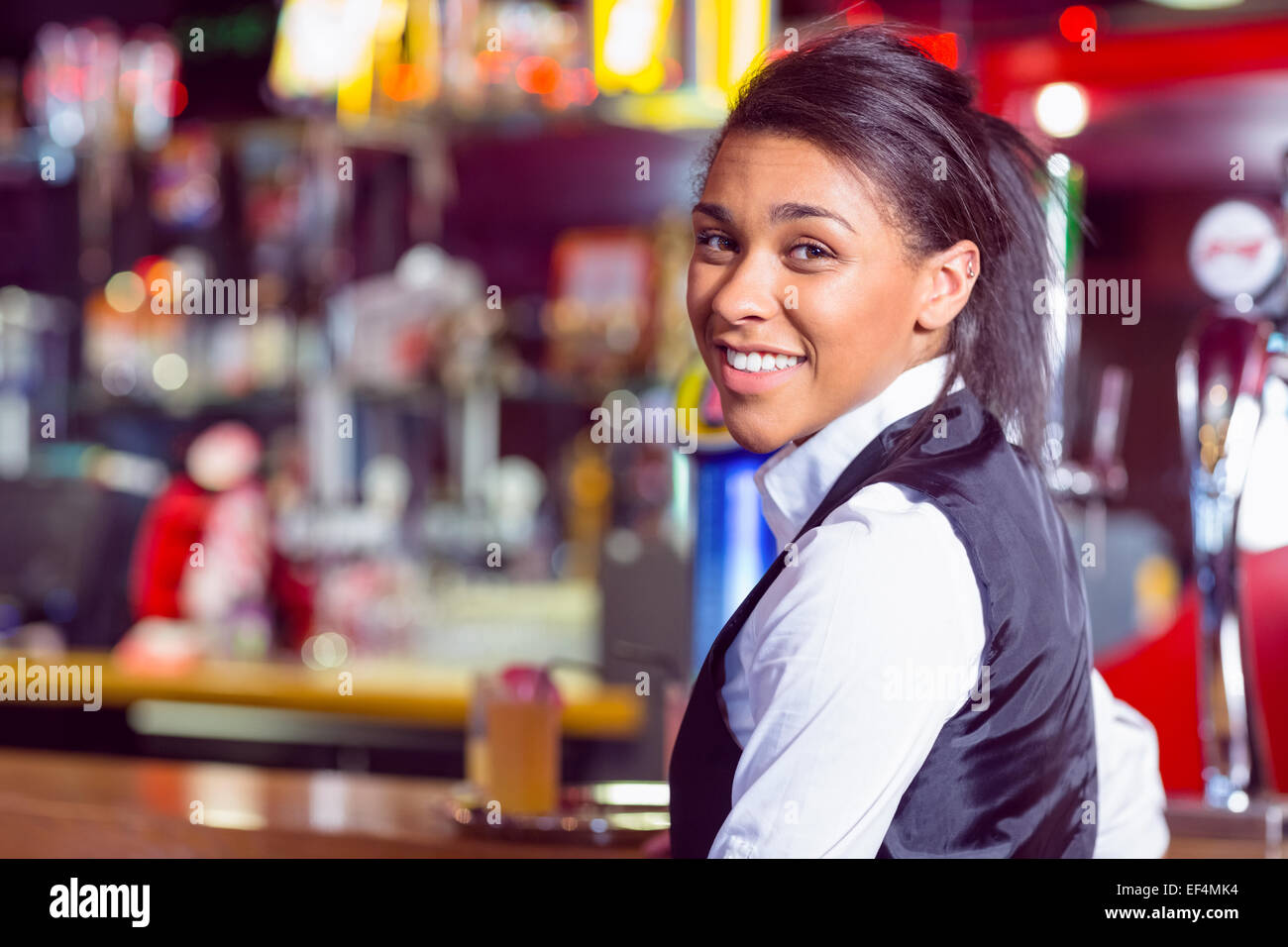 Pretty barmaid smiling at camera Stock Photo - Alamy