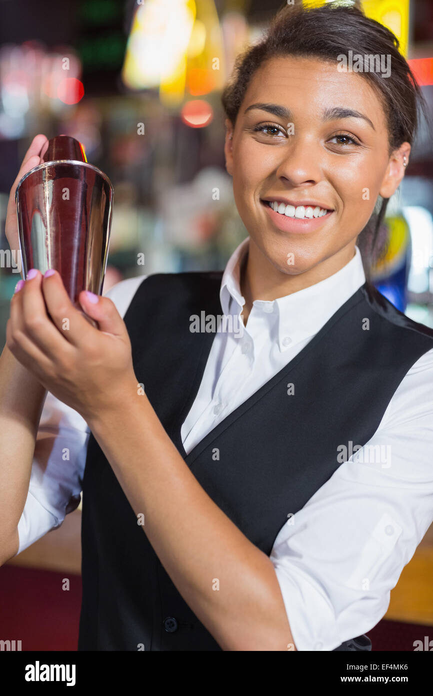 Pretty barmaid shaking up cocktail Stock Photo - Alamy