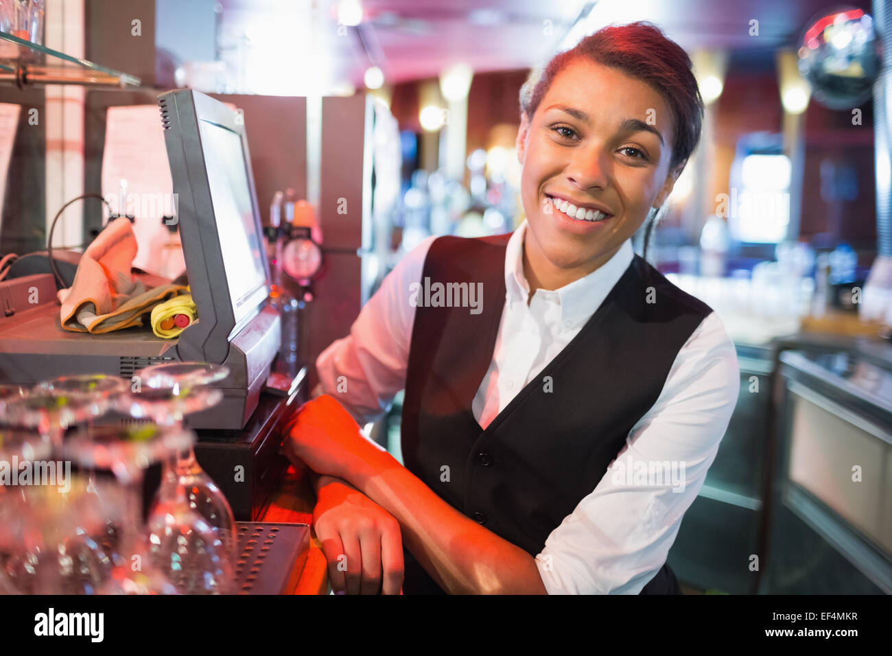 Pretty barmaid smiling at camera Stock Photo - Alamy