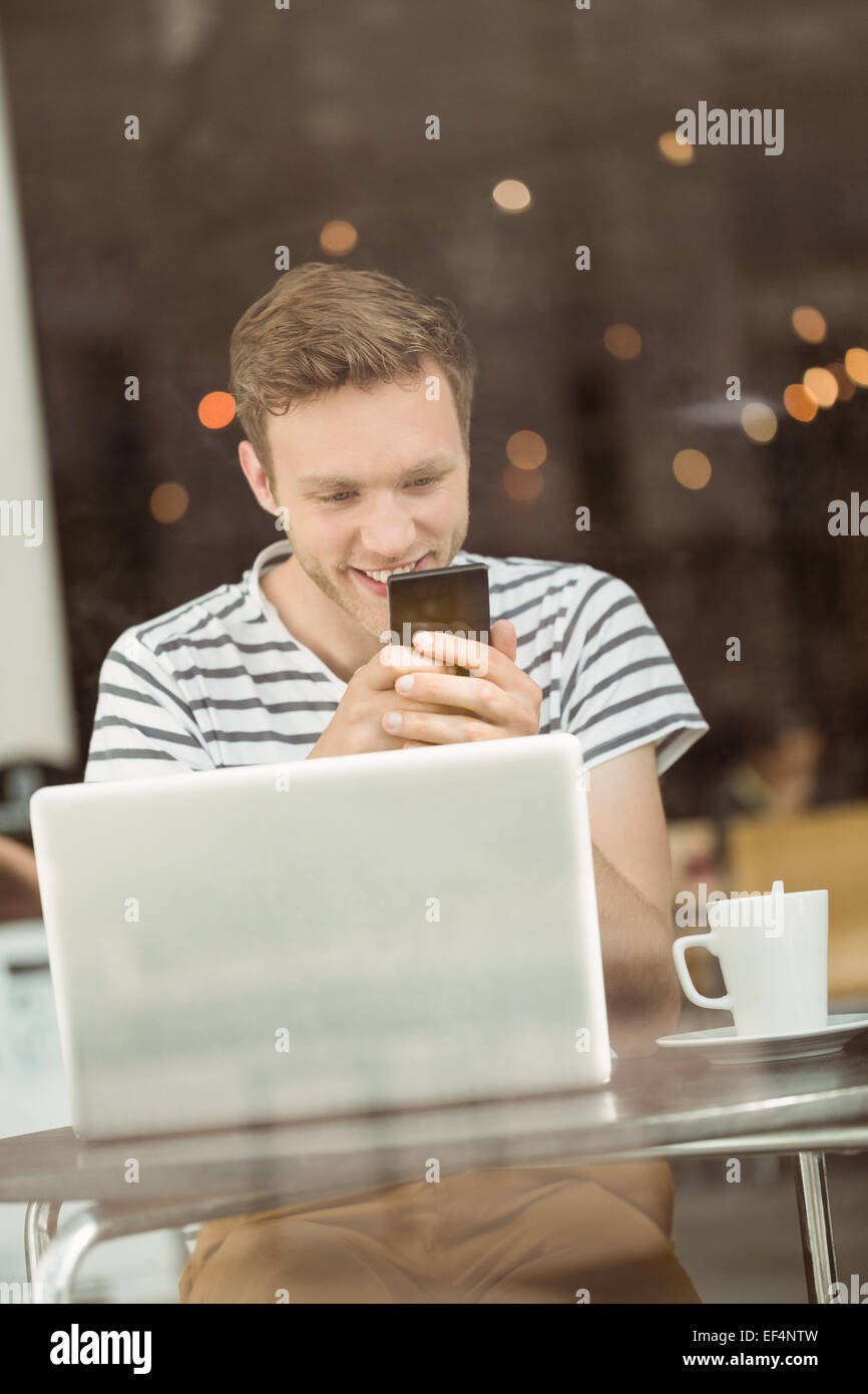 Smiling student touching his mobile phone Stock Photo - Alamy