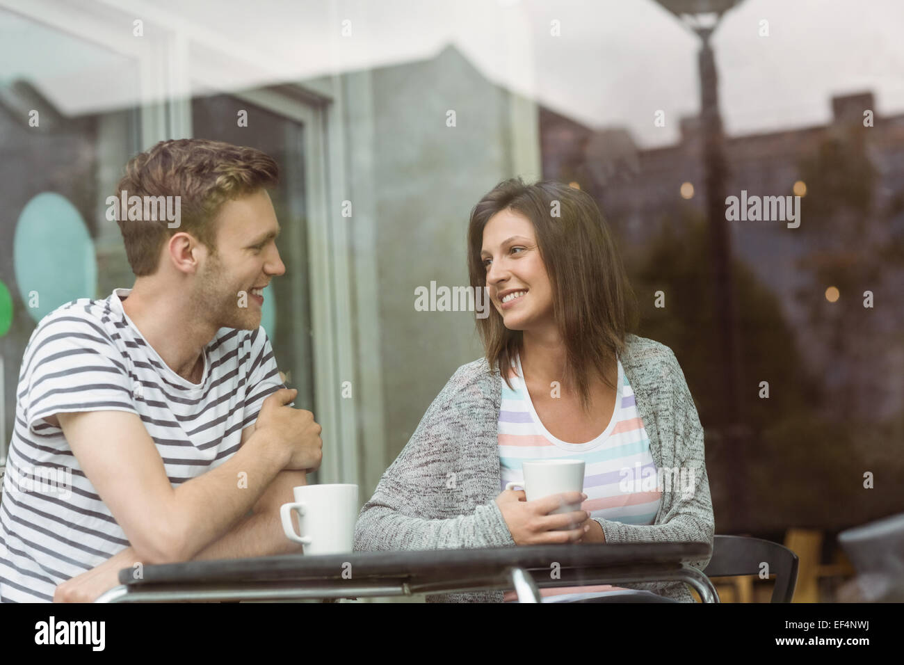 Smiling friends with mug of coffee Stock Photo - Alamy