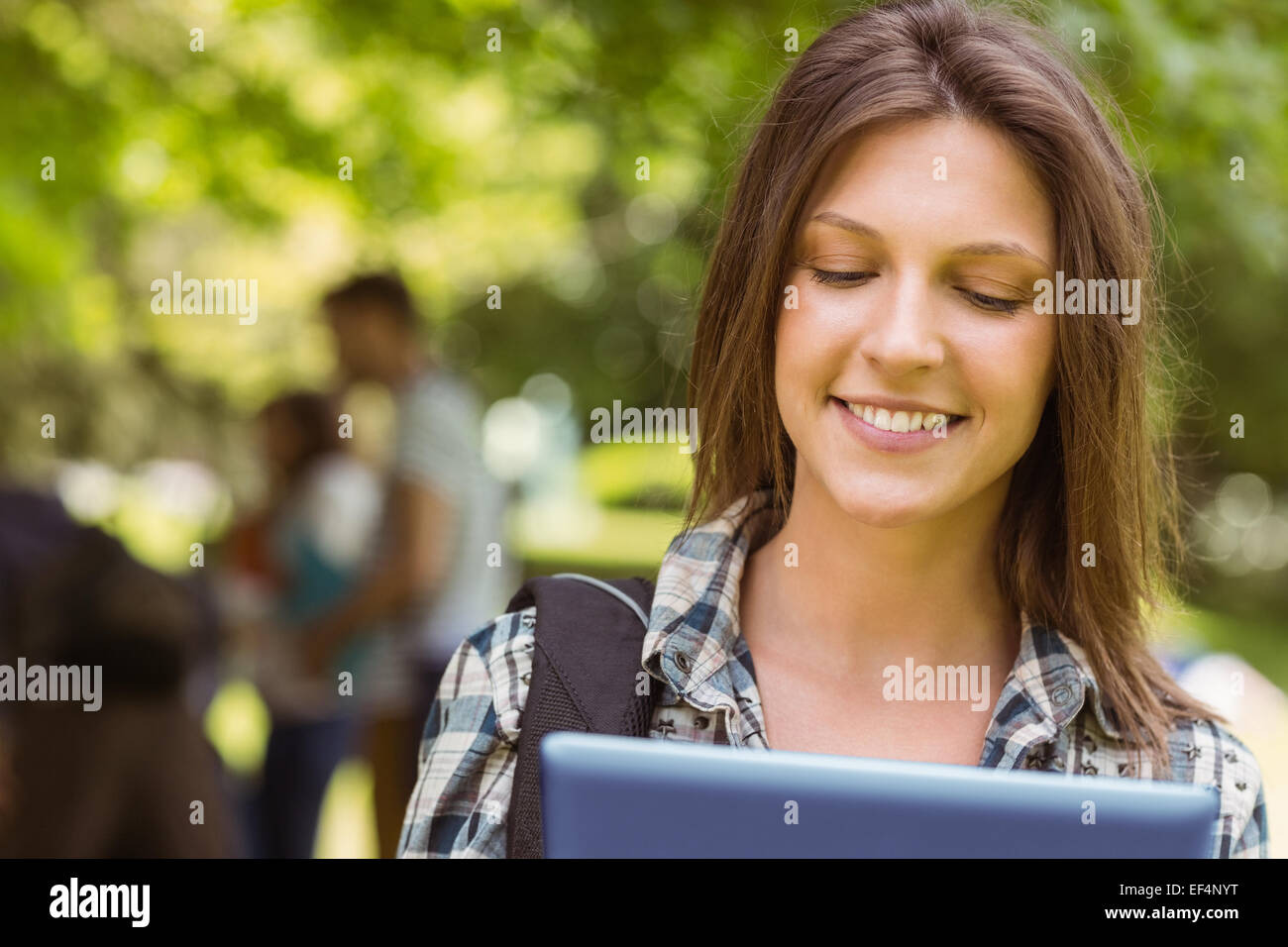 Smiling student with a shoulder bag and using tablet computer Stock ...