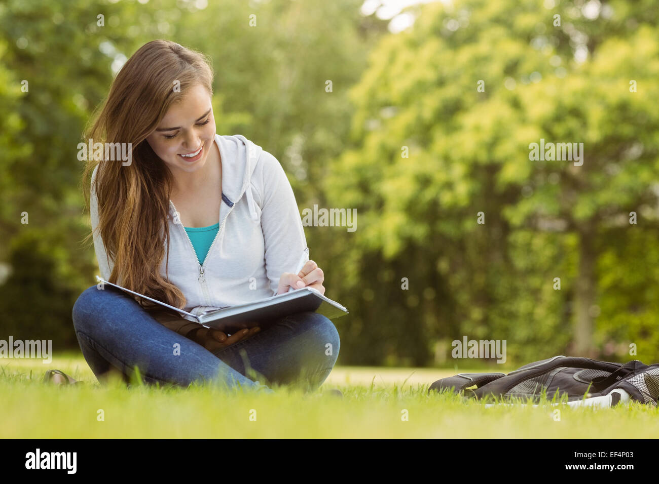 Smiling student sitting and reading book Stock Photo - Alamy