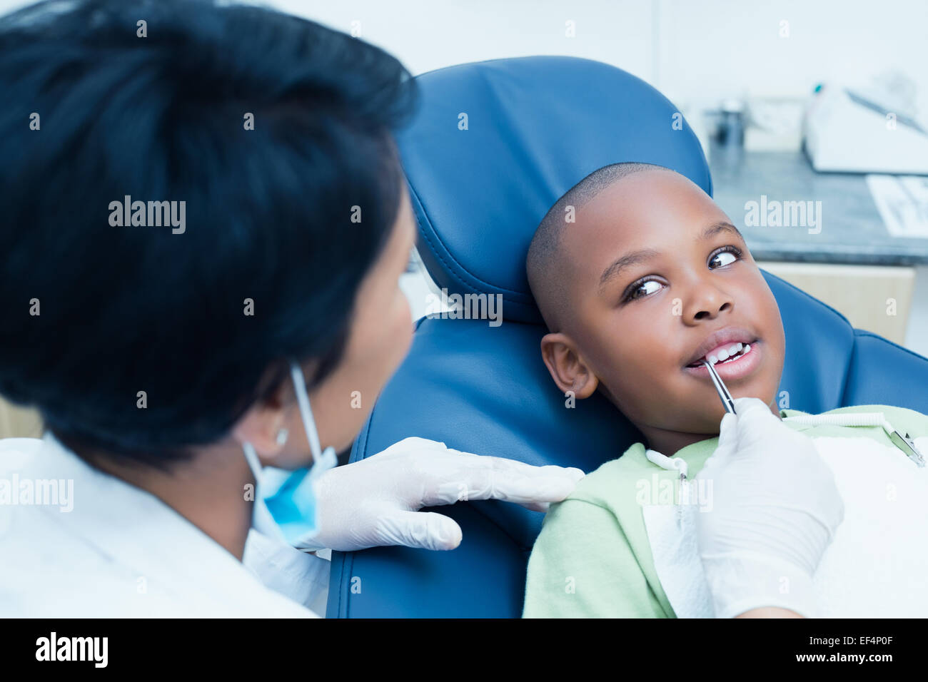 Dentist examining boys teeth in dentists chair Stock Photo - Alamy