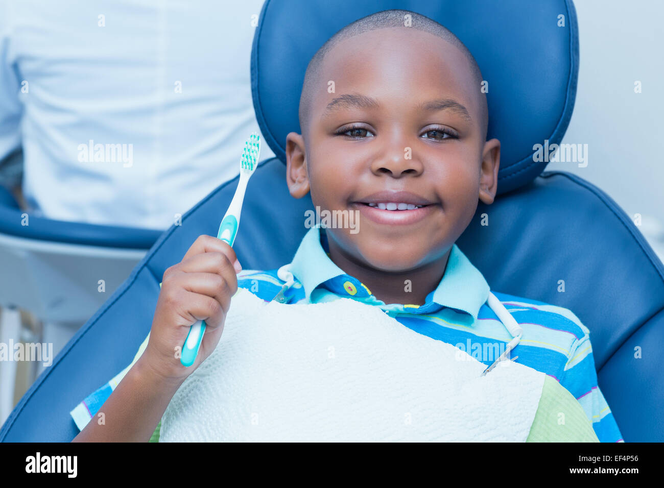 Boy holding toothbrush in the dentists chair Stock Photo - Alamy