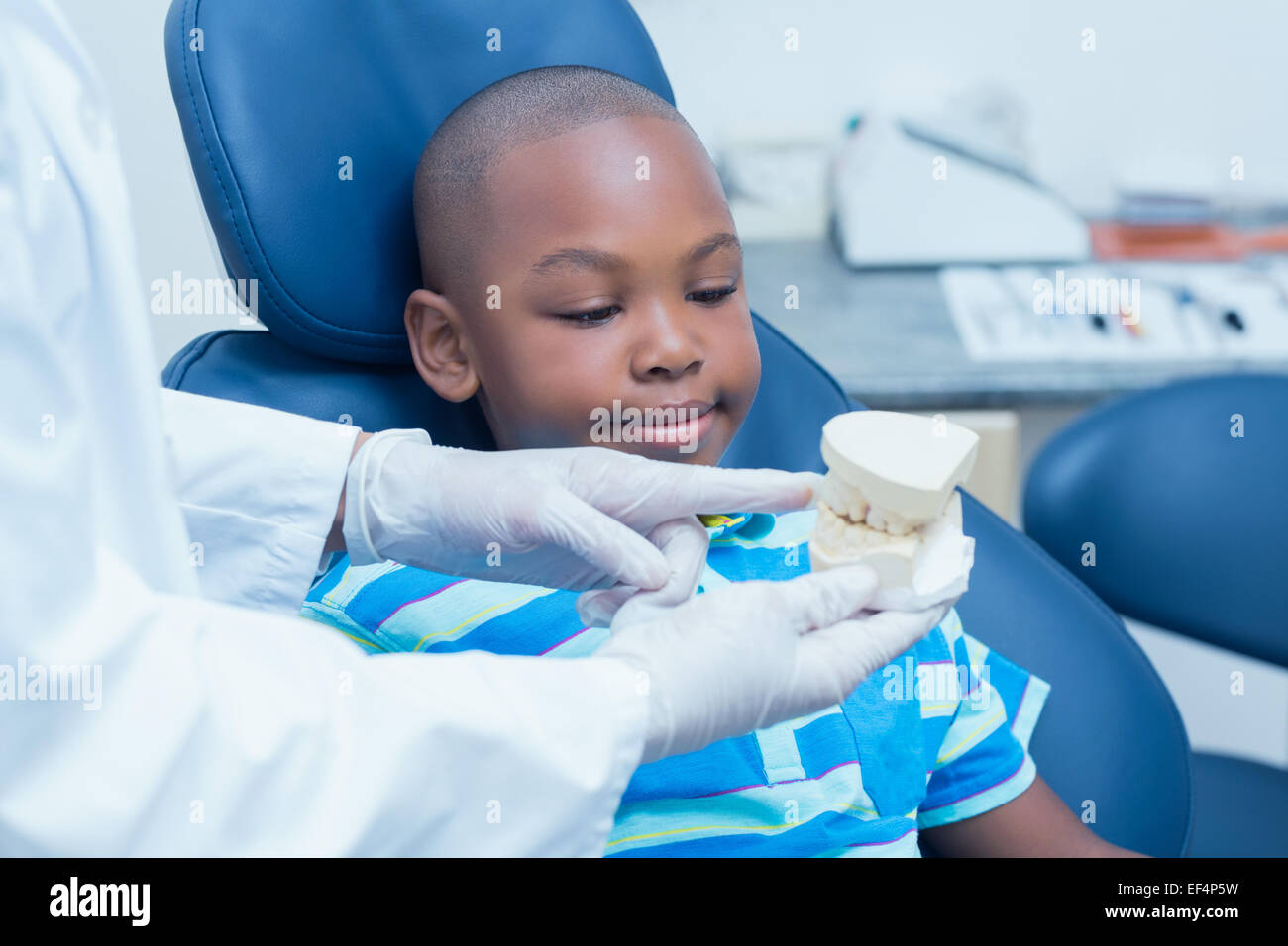 Cropped dentist showing boy prosthesis teeth Stock Photo - Alamy