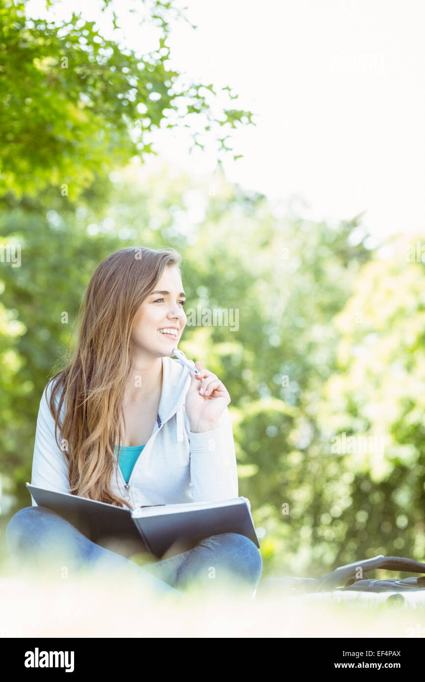 Thinking student sitting and holding book Stock Photo - Alamy
