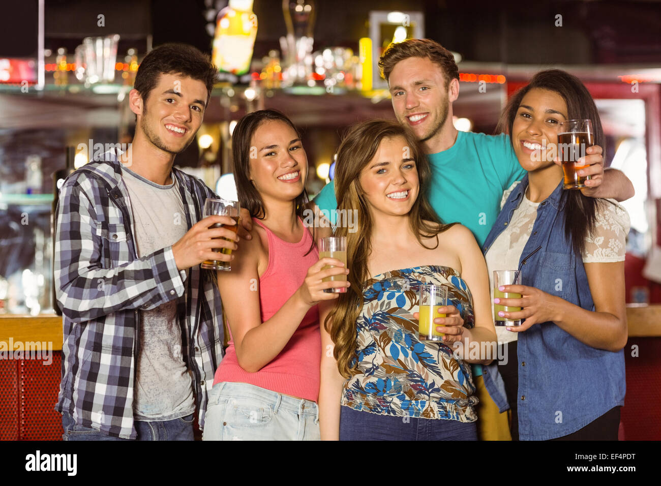 Smiling friends drinking beer and mixed drink Stock Photo - Alamy