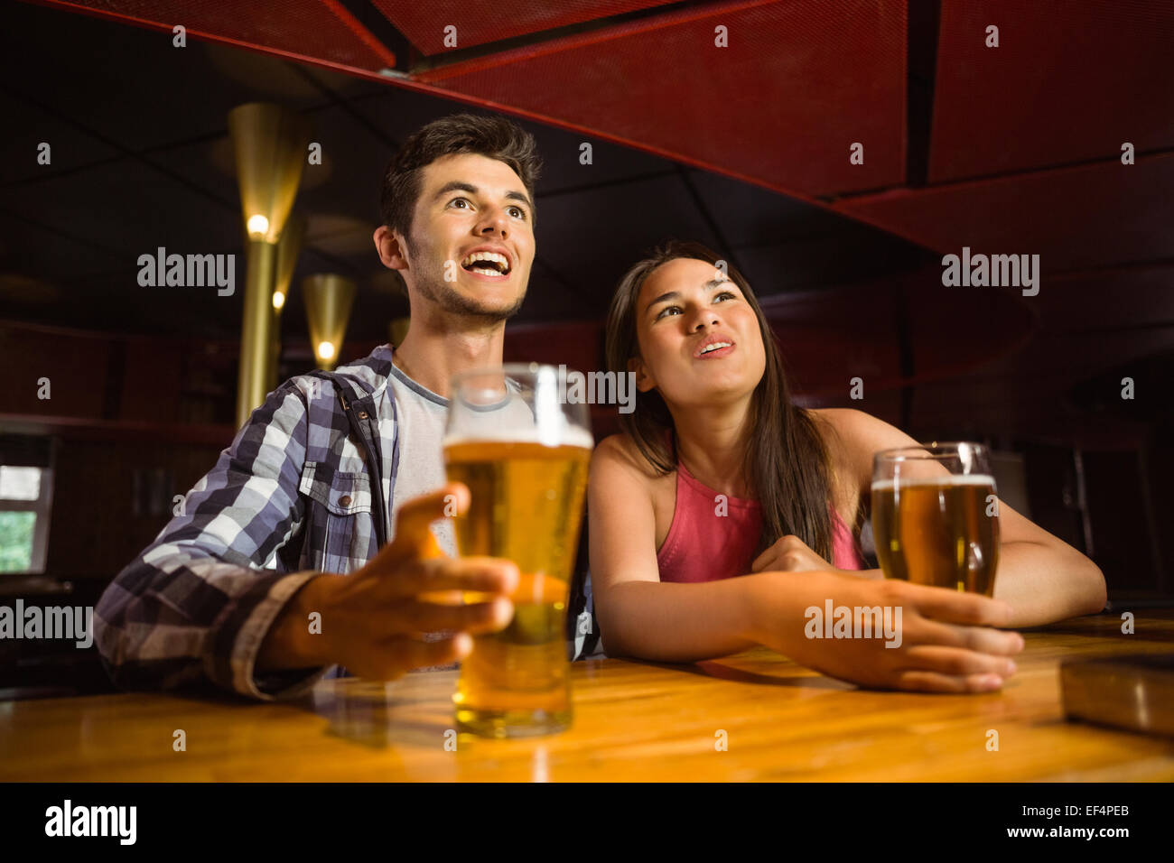 Smiling friends drinking beer together Stock Photo - Alamy