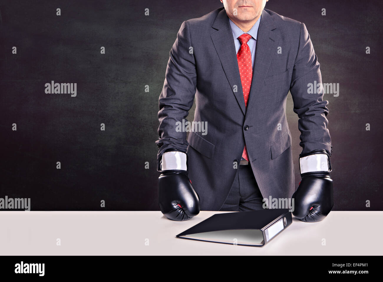 portrait of a male office worker with boxing gloves in the defensive ...