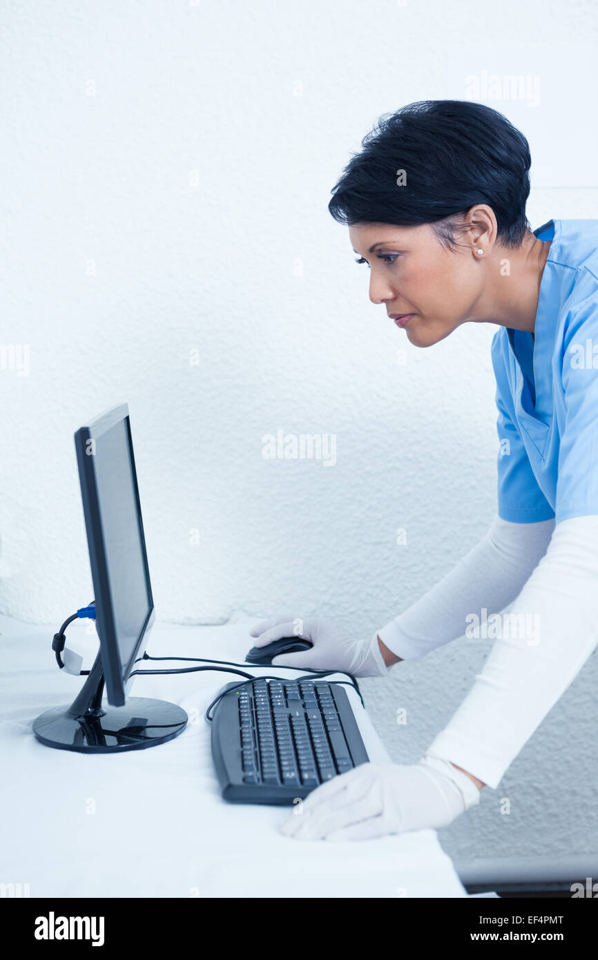 Female dentist looking at computer monitor Stock Photo - Alamy