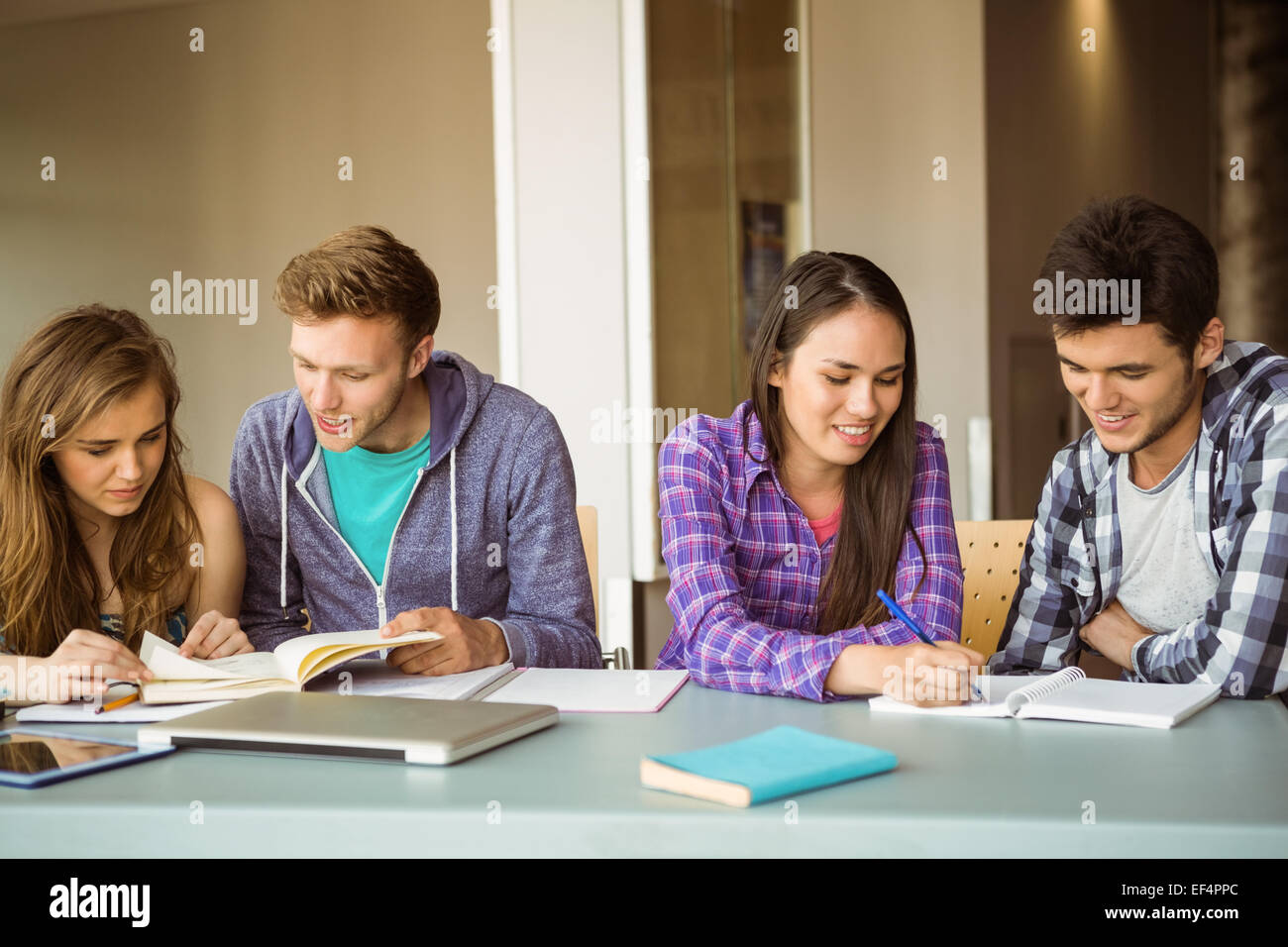 Smiling friends students revising together Stock Photo - Alamy