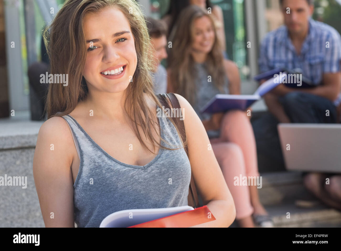 Pretty student smiling at camera outside Stock Photo - Alamy