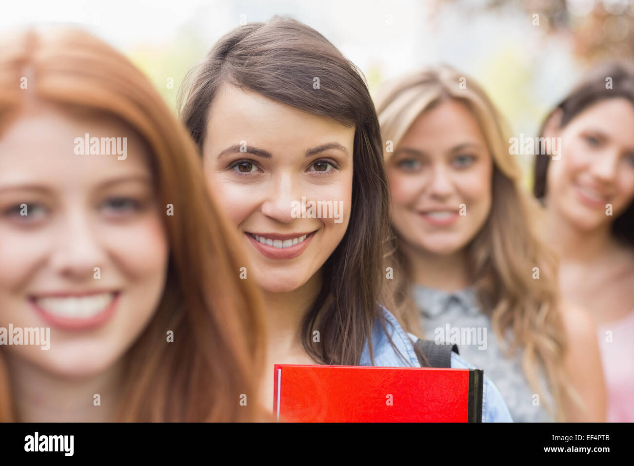 Happy students smiling at camera in a row Stock Photo - Alamy