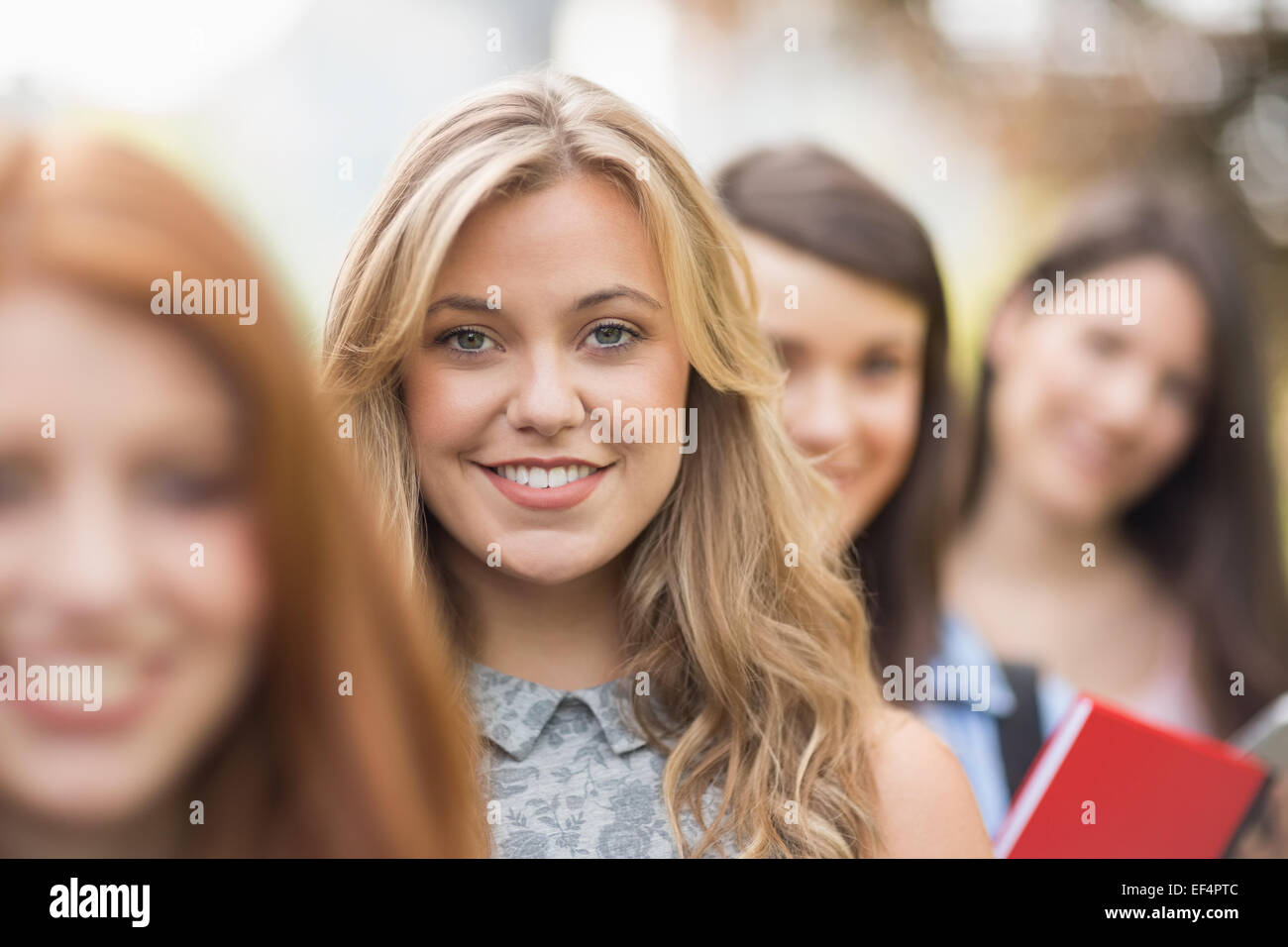 Happy students smiling at camera in a row Stock Photo - Alamy
