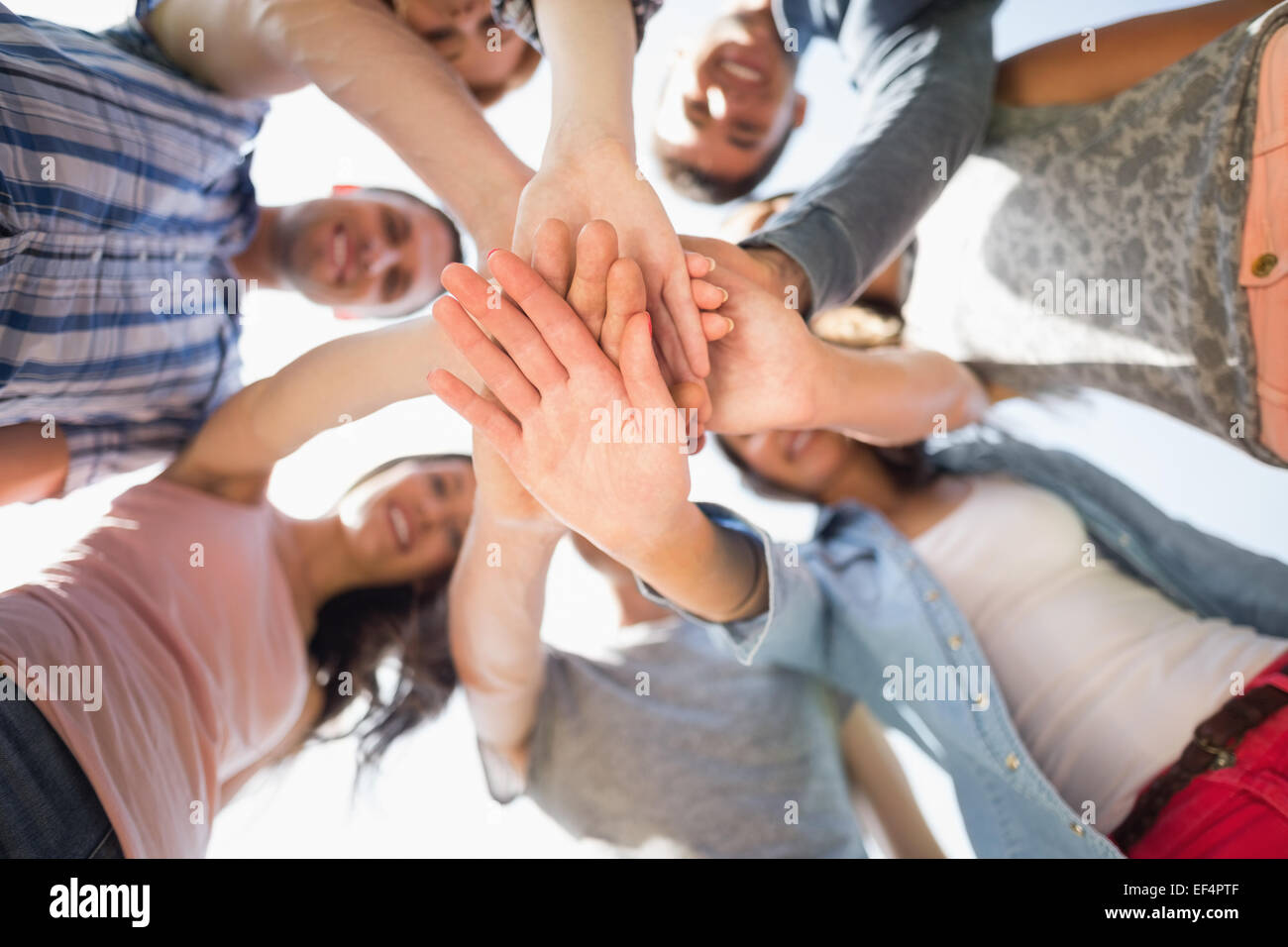 Happy students putting their hands together Stock Photo - Alamy