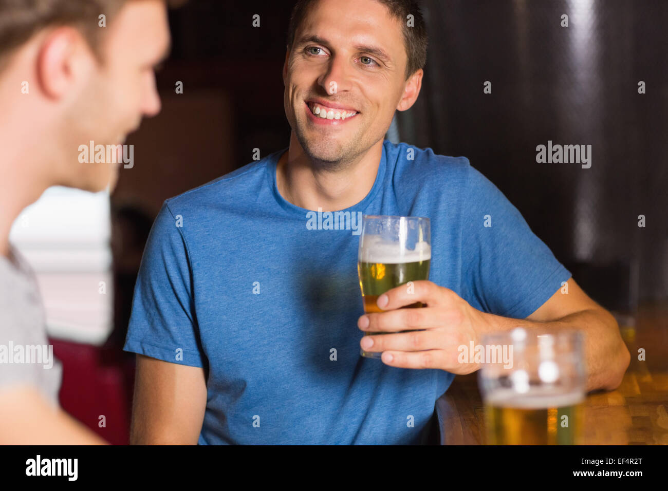 Happy friends catching up over pints Stock Photo - Alamy