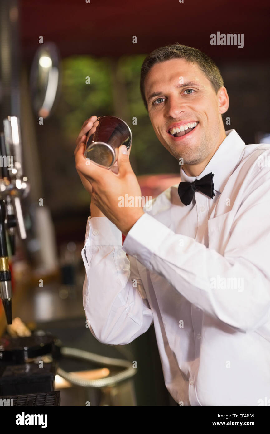 Handsome barman smiling at camera making a cocktail Stock Photo - Alamy