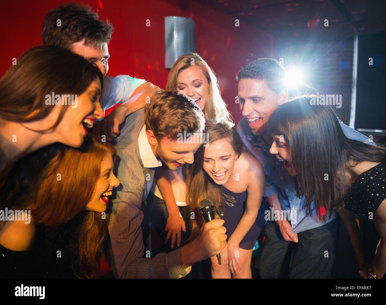 Happy friends singing karaoke together Stock Photo - Alamy