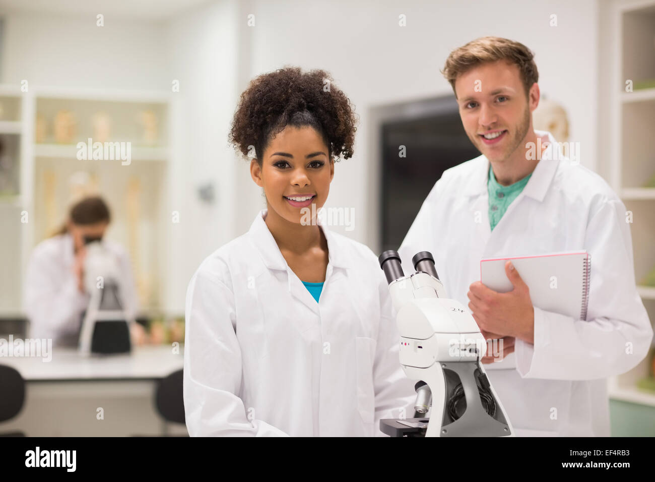 Happy medical students working with microscope Stock Photo - Alamy