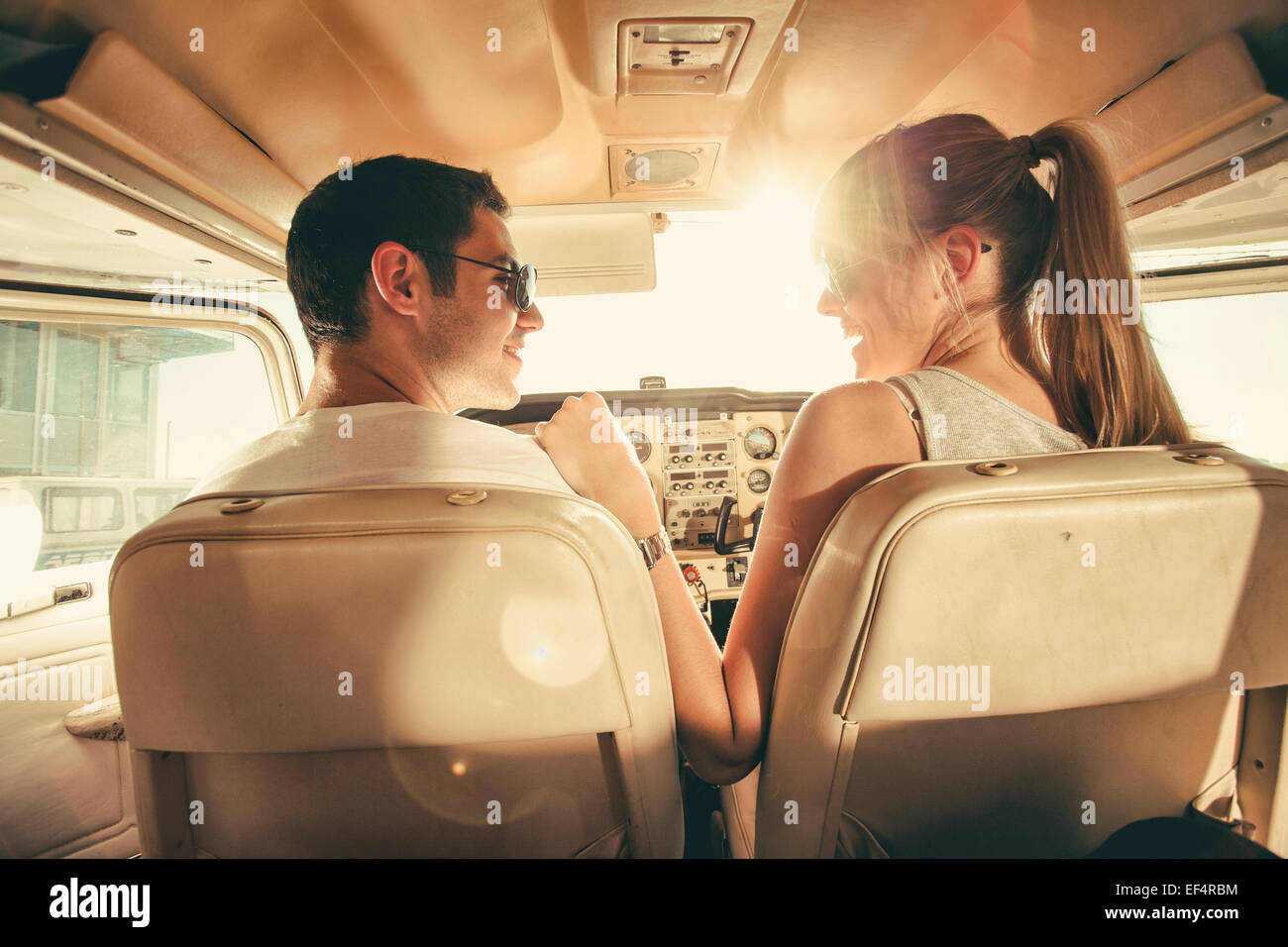 Young couple sitting in cockpit of propeller airplane Stock Photo - Alamy