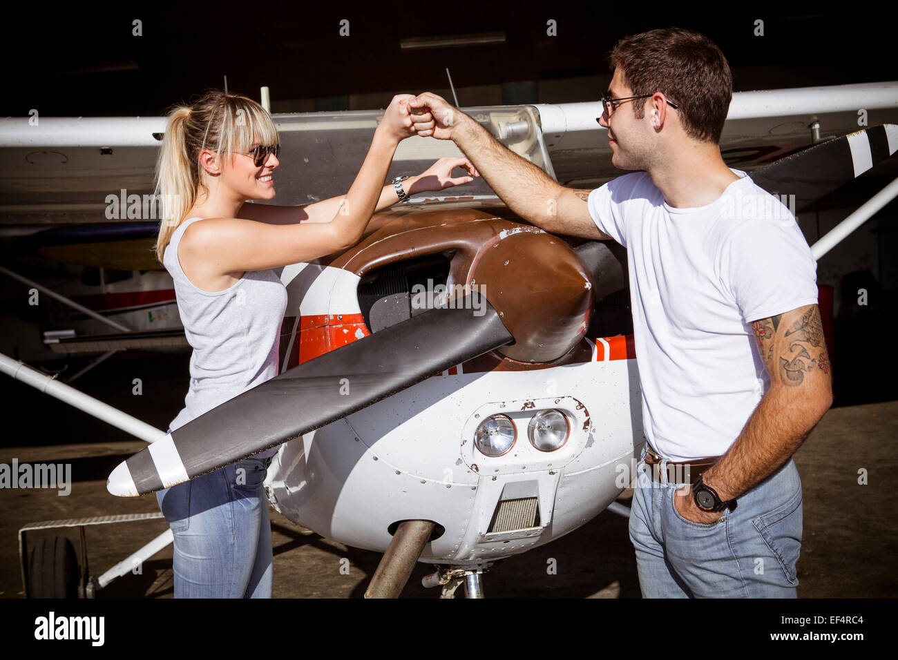 Young couple preparing for start in propeller airplane Stock Photo - Alamy